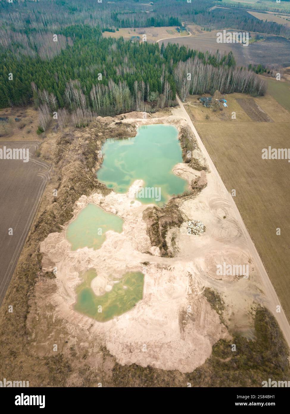 Aerial perspective of a sand quarry featuring turquoise water pools ...
