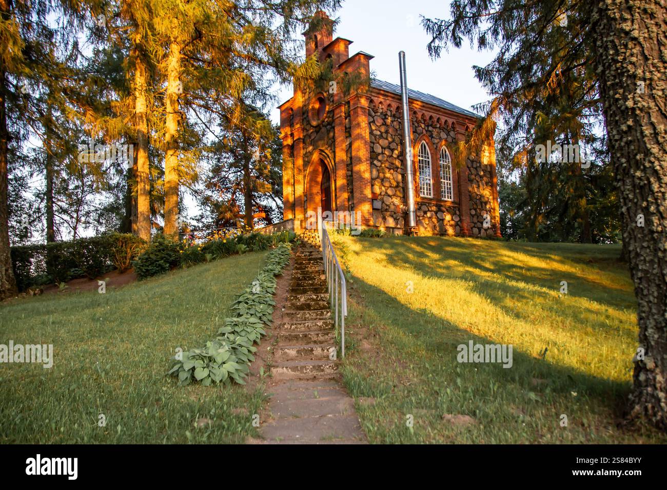 A small brick chapel with arched windows and a patterned facade sits on ...