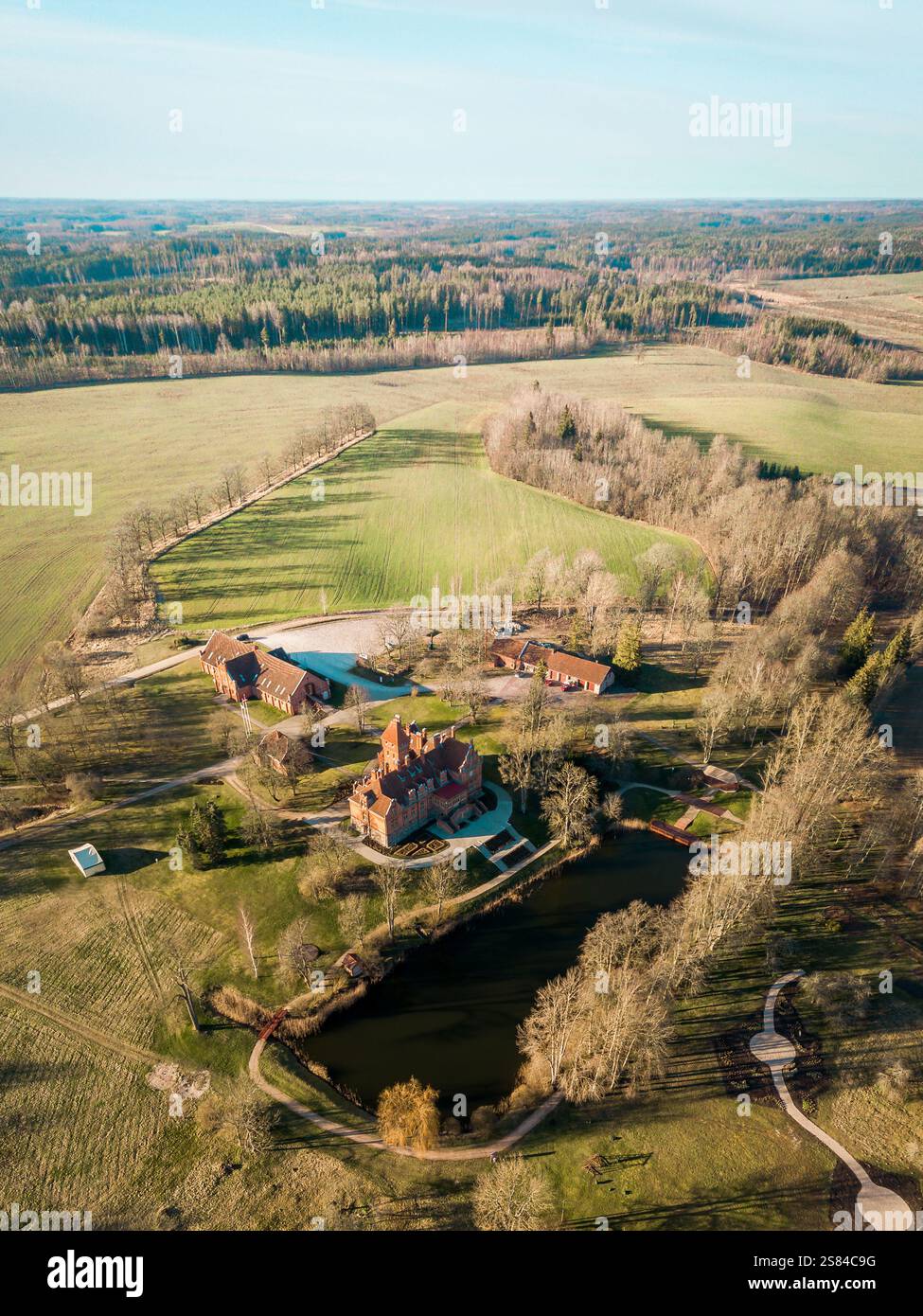 Aerial perspective of a red brick mansion surrounded by open fields ...