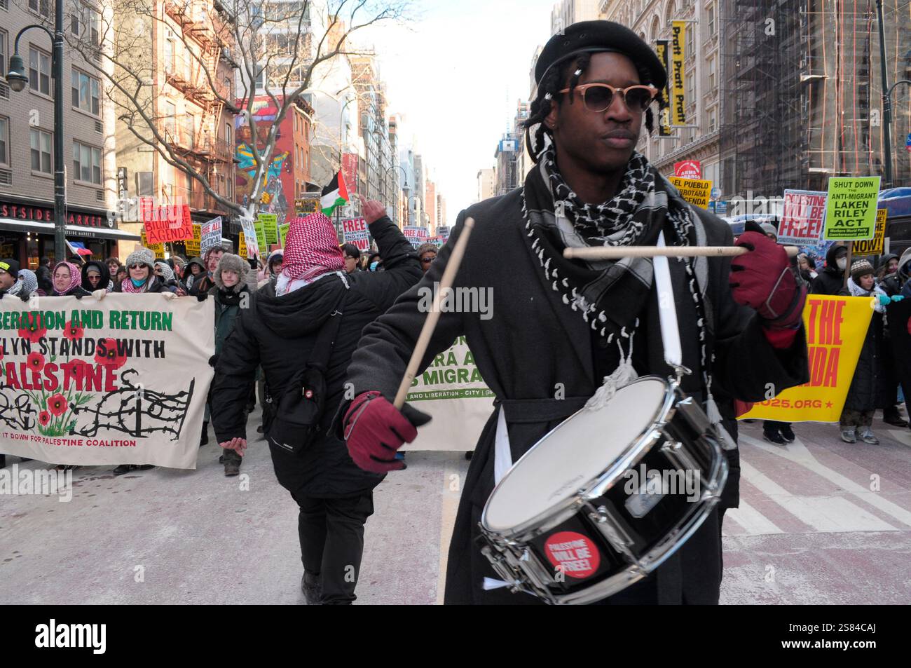 An anti-Trump demonstrator marches while playing a drum in Manhattan ...