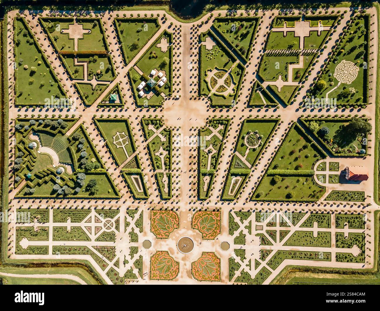 Aerial view of a formal garden featuring geometric pathways, a central fountain, hedges, flower ...