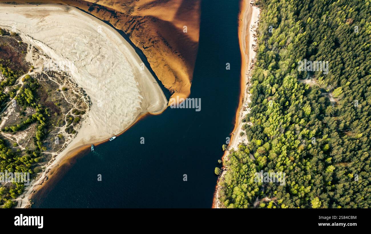 Aerial perspective of a winding river with dark blue water, bordered by ...