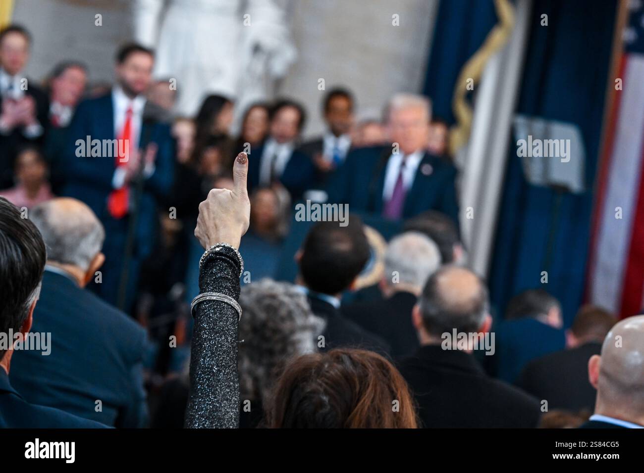 A supporter raises their hand while President Donald Trump speaks ...