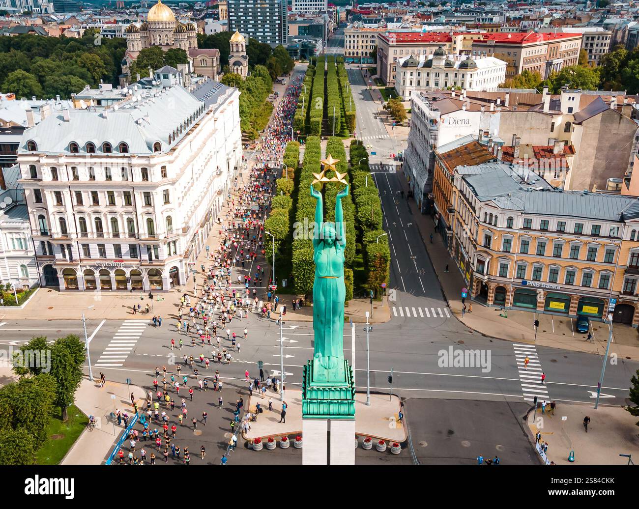 The Freedom Monument in Riga, Latvia, with a tree lined boulevard ...