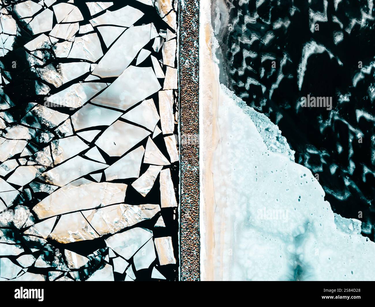 Fractured ice sheets with jagged patterns meet dark rippling water ...