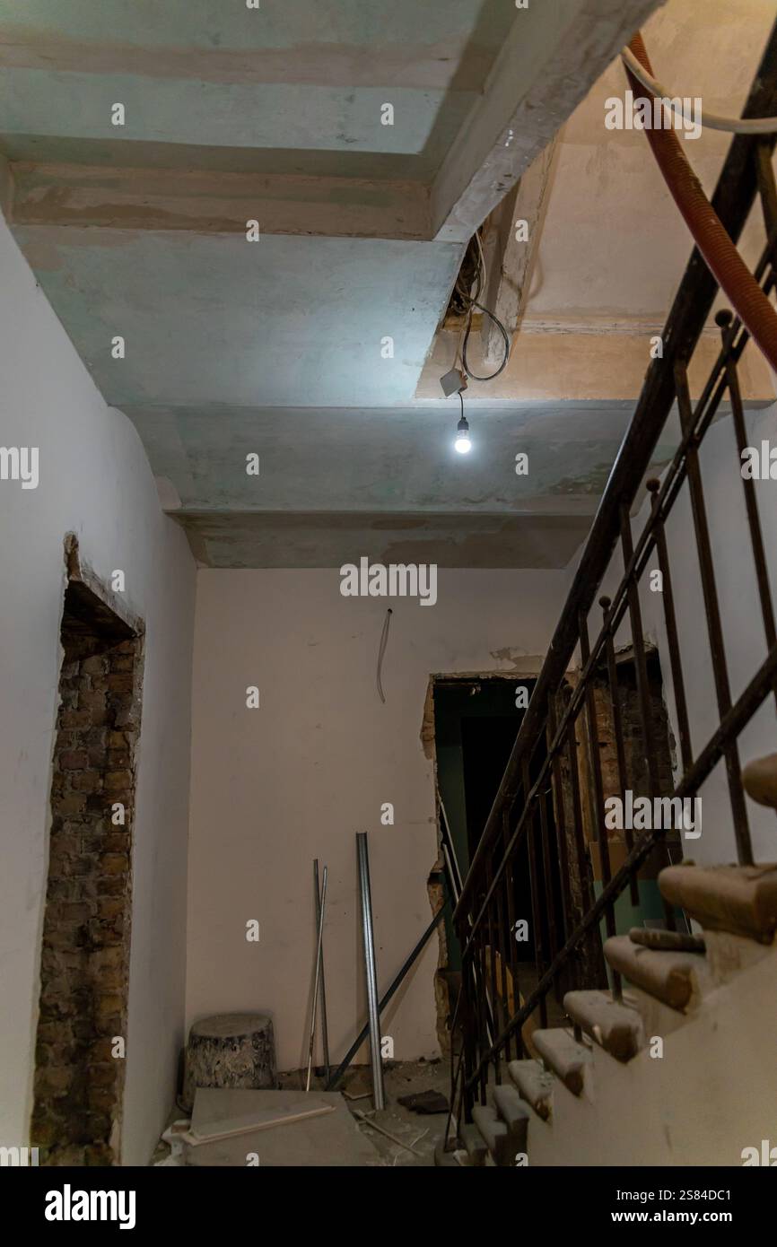 Unfinished interior with exposed brick walls, a metal railed staircase ...