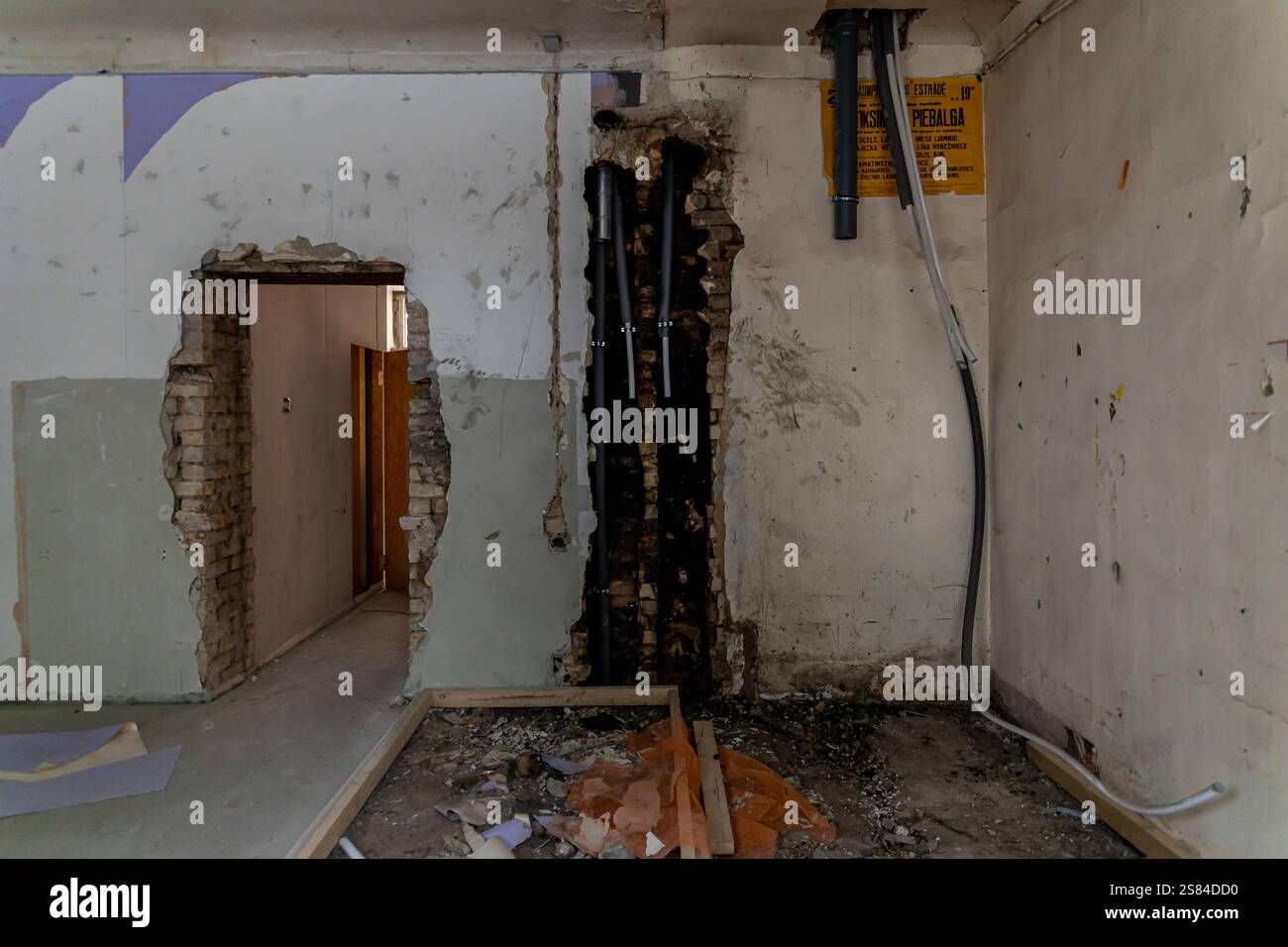 A partially demolished interior space with exposed brick walls, visible ...