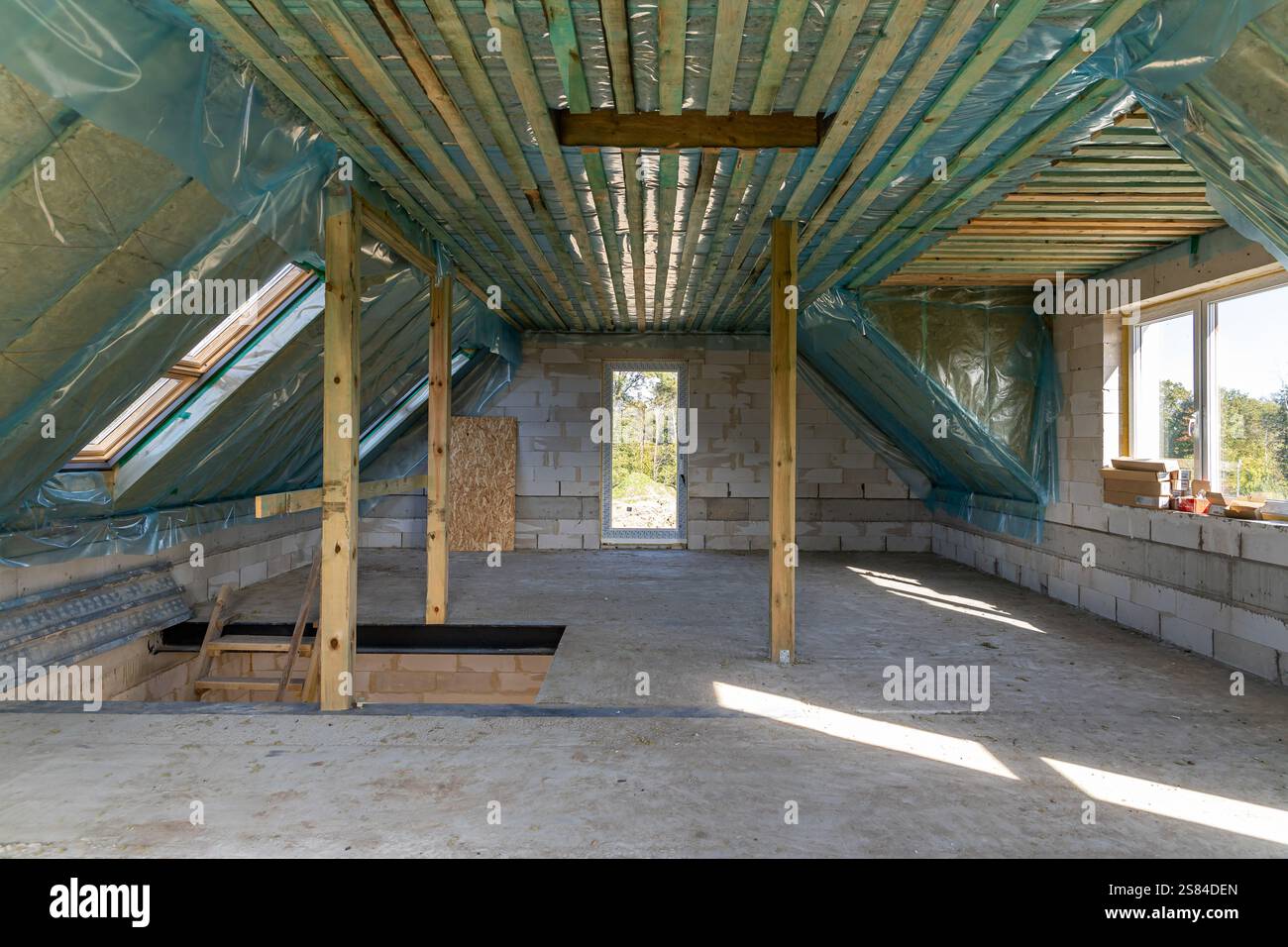 Interior of an under construction attic featuring sloped ceilings with ...