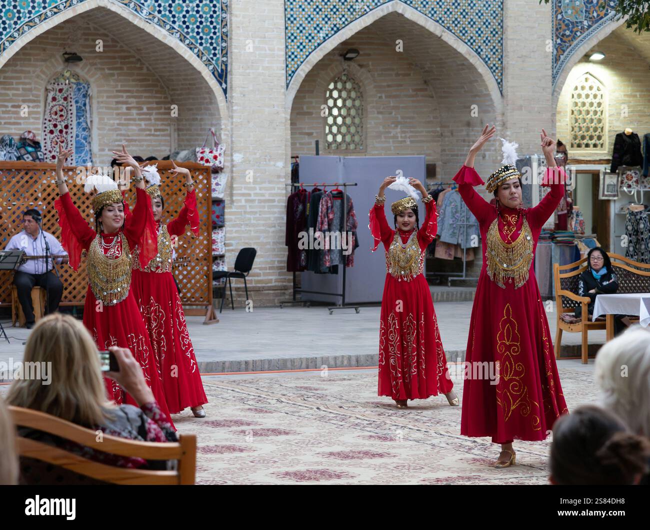 Four women in red gowns performing a traditional Uzbek dance in the ...