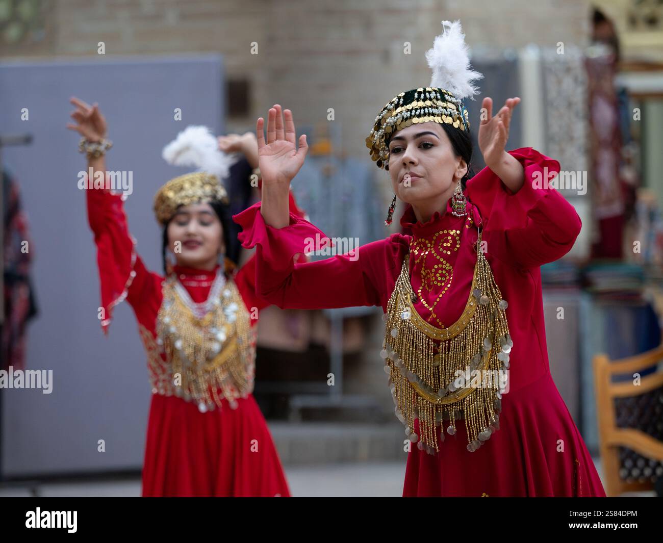 Close up of a woman in a red gown performing a traditional Uzbek dance ...