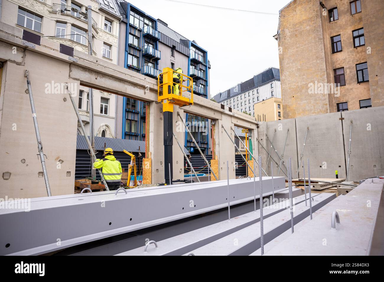 Active construction site in a city, featuring workers, scaffolding, a ...