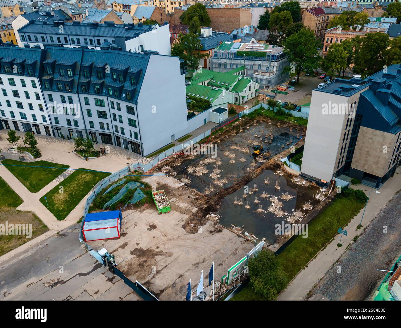 An urban construction site with machinery and materials, surrounded by ...