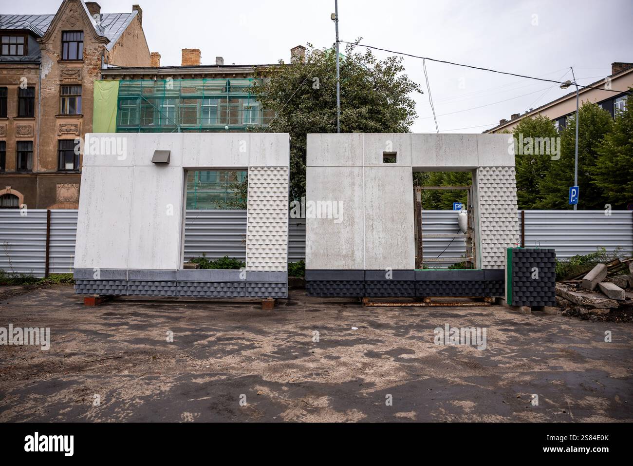 Construction site featuring two modern concrete structures with ...