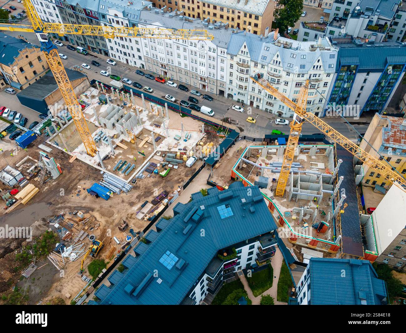 Active construction site with two yellow tower cranes, surrounded by ...