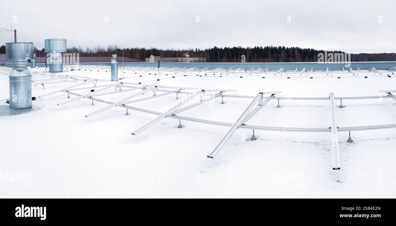 A rooftop covered in snow features metal frameworks for solar panels ...