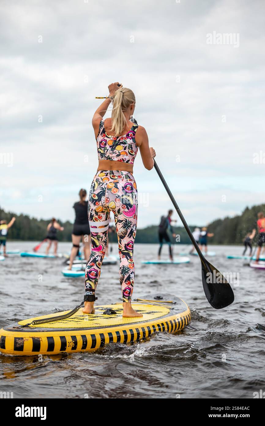 A group of paddleboarders enjoys outdoor recreation on calm water. A ...