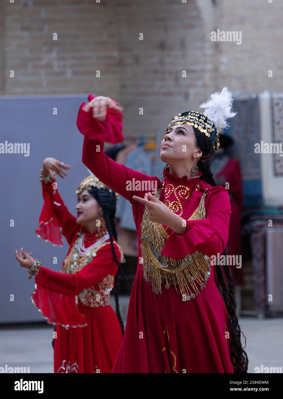 Close up of a woman in a red gown performing a traditional Uzbek dance ...
