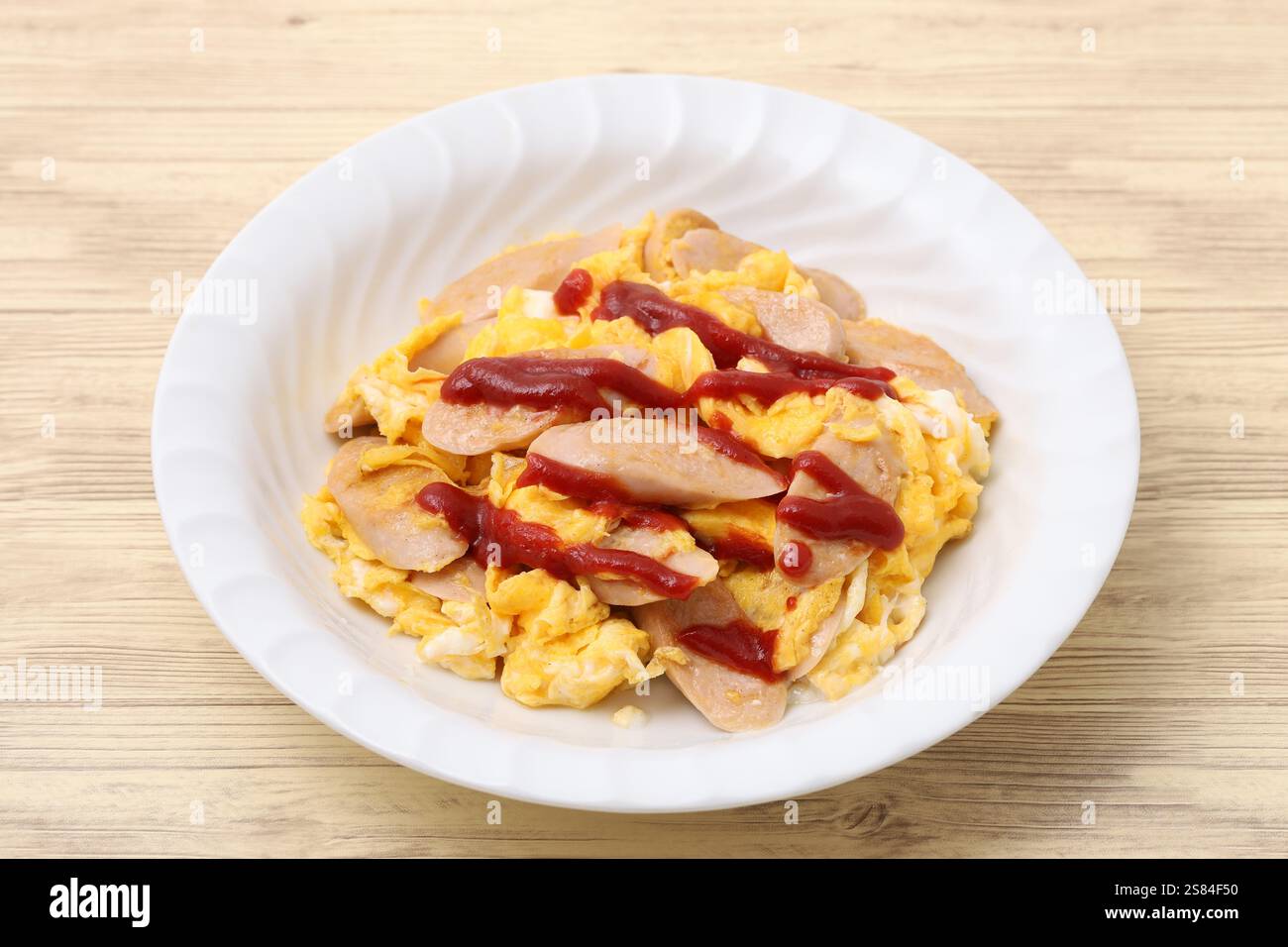 Fried fish meat sausage and eggs in a plate on table background Stock ...
