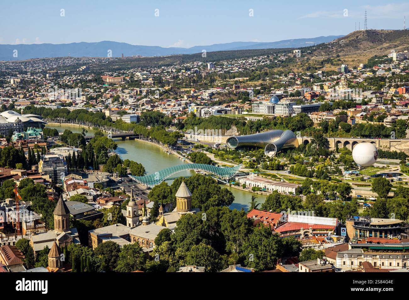 View of Tbilisi, Georgia, featuring the Kura River, Bridge of Peace ...