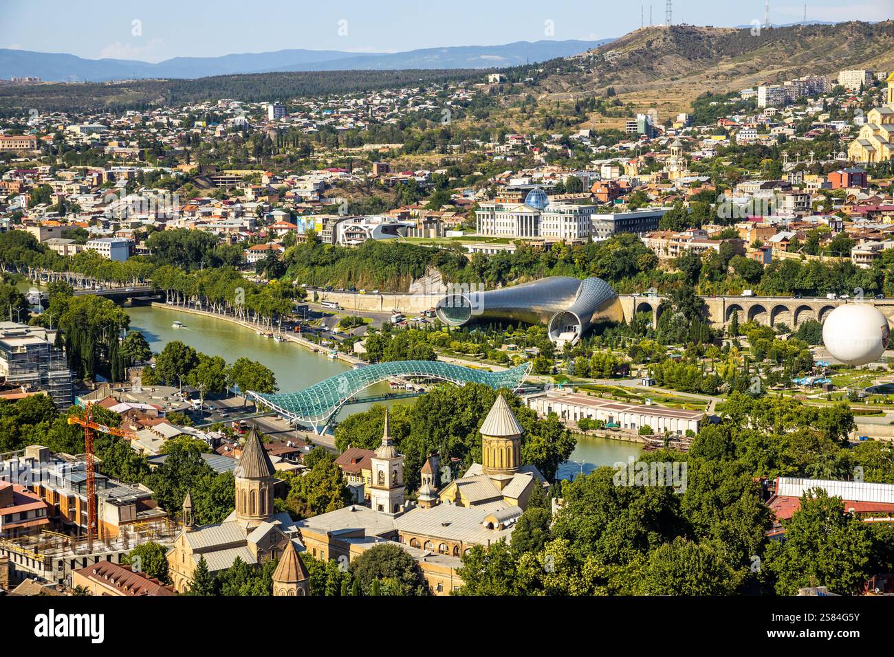 View of Tbilisi, Georgia, featuring the Kura River, Bridge of Peace ...