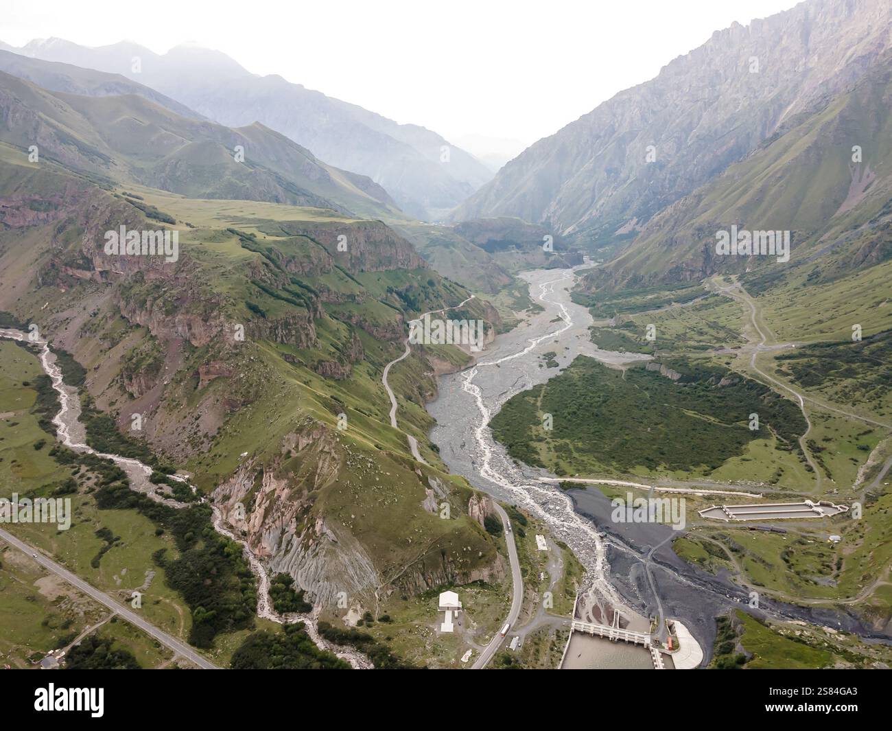 A winding river flows through a valley in Georgia, surrounded by cliffs ...