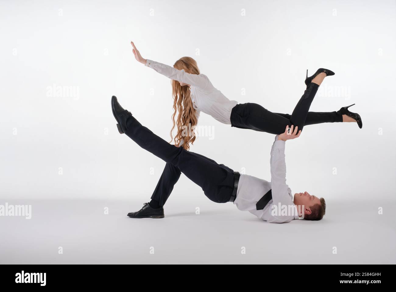 Couple performs acrobatic pose showing teamwork and balance in a studio ...