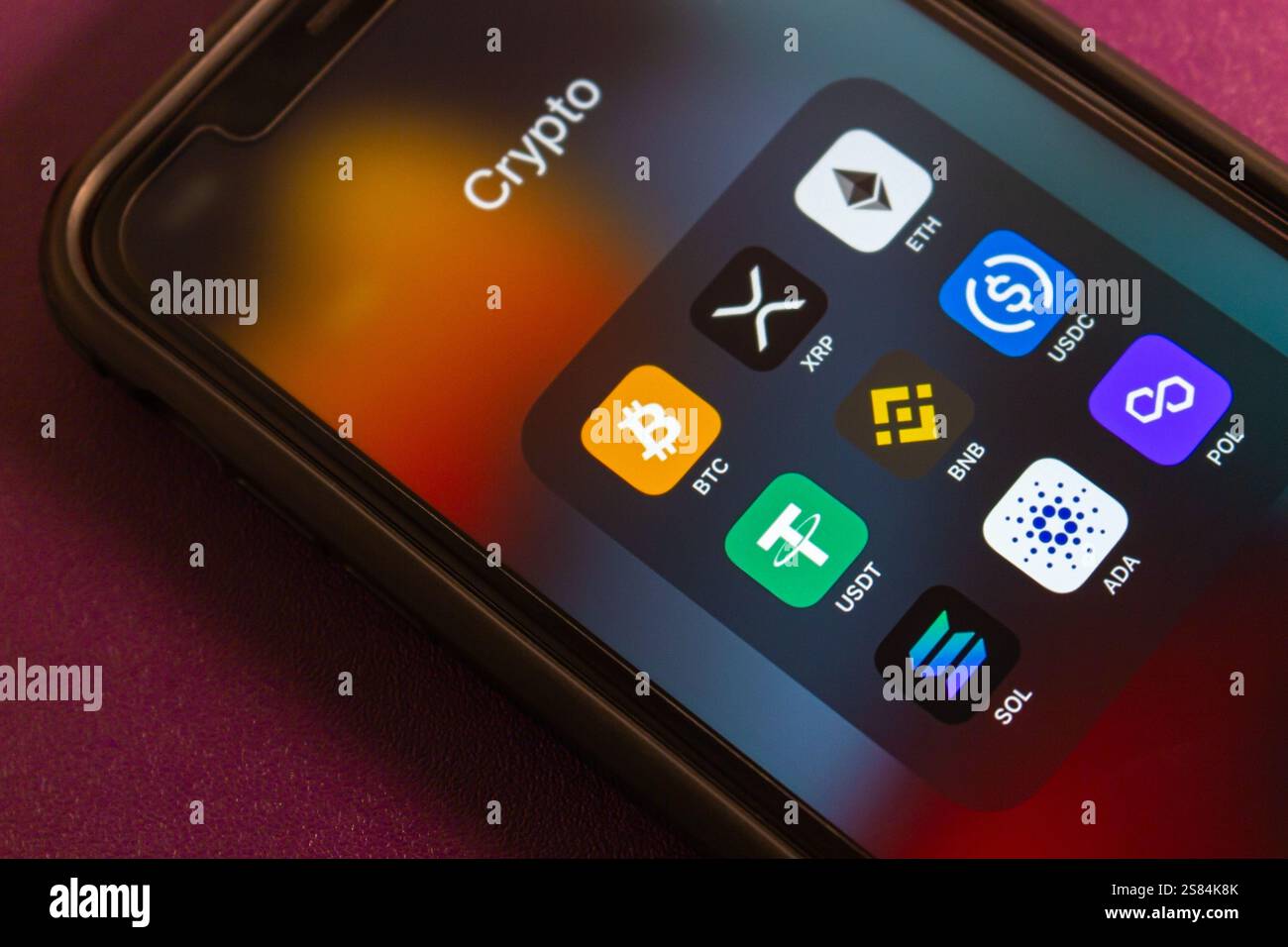 BTC (Bitcoin) and other cryptocurrency icons are displayed on an iPhone ...