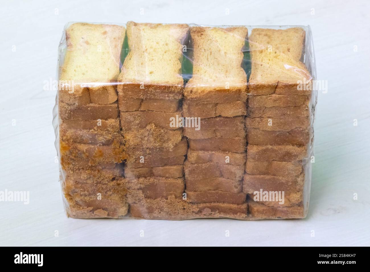 A packet of crispy rusk toast, dry cake biscuits are kept on a light ...