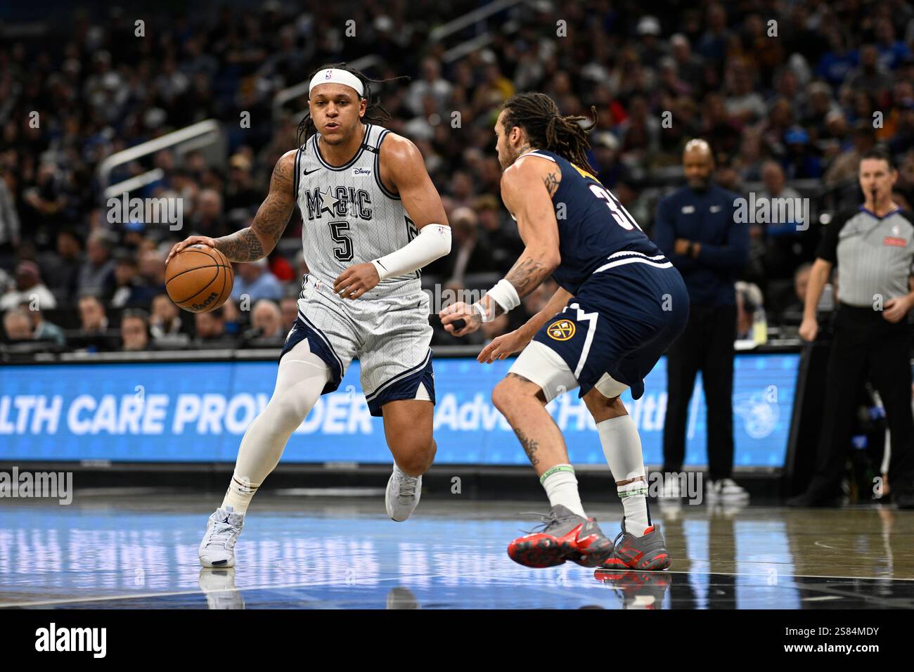 Orlando Magic forward Paolo Banchero (5) is defended by Denver Nuggets ...