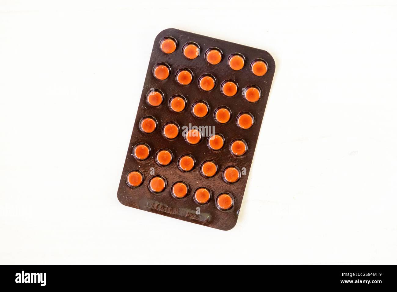 Orange tablets in a blister pack, isolated on a white background ...