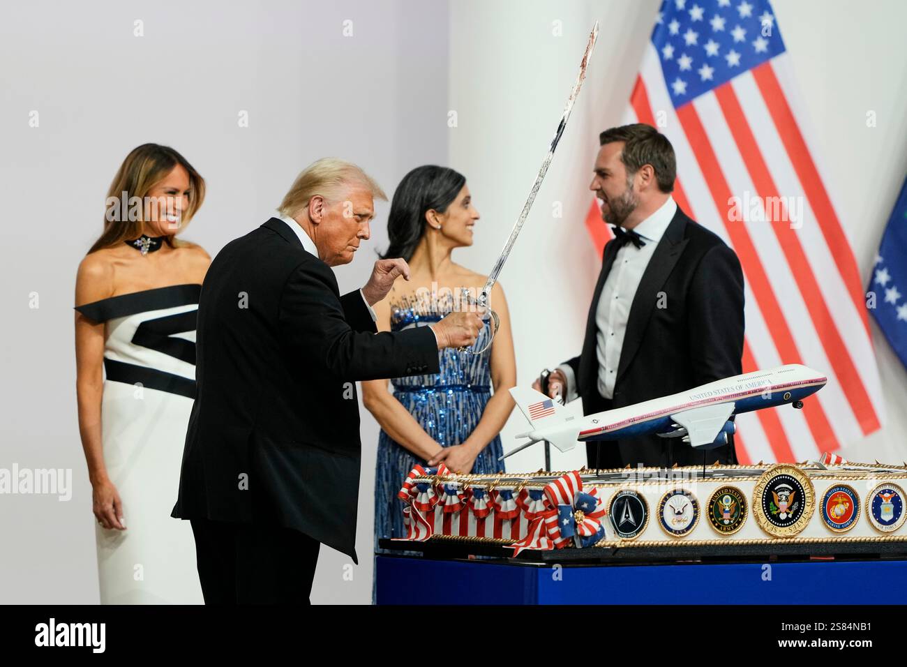 President Donald Trump, second from left, holds a sabre after using it ...