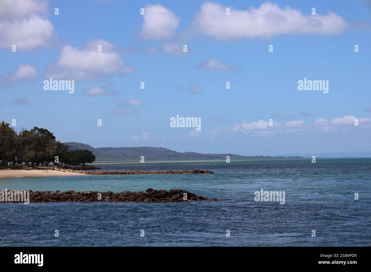 blue seas, sandy beach, scattered puffy white clouds, sunny skies Stock ...