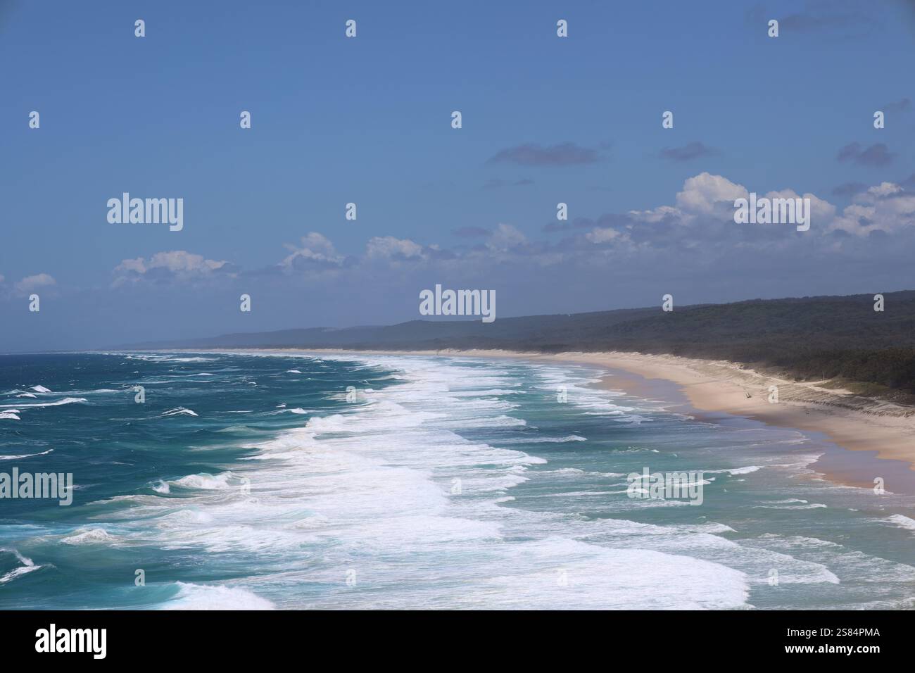 blue ocean water turns to frothy white foam as it rolls ashore on sandy ...