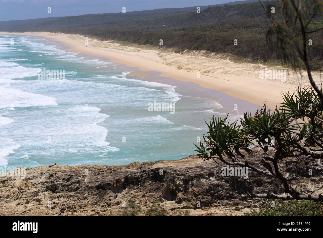 gentle waves rolling onto sandy beaches viewed from above on a rocky shore Stock Photo - Alamy