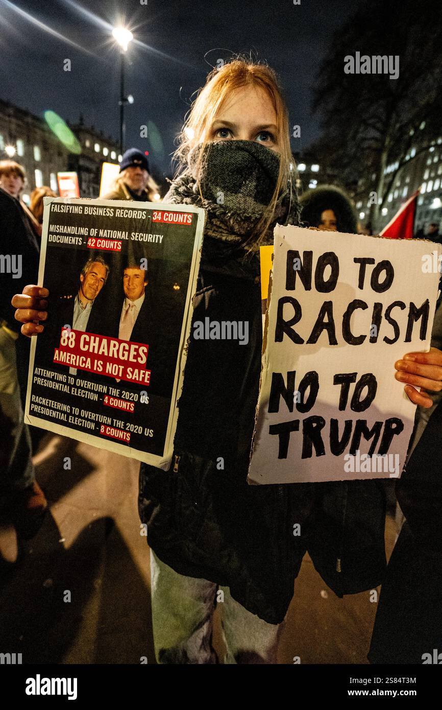 London, UK. 20th Jan, 2025. An anti-Trump demonstrator holds placards ...