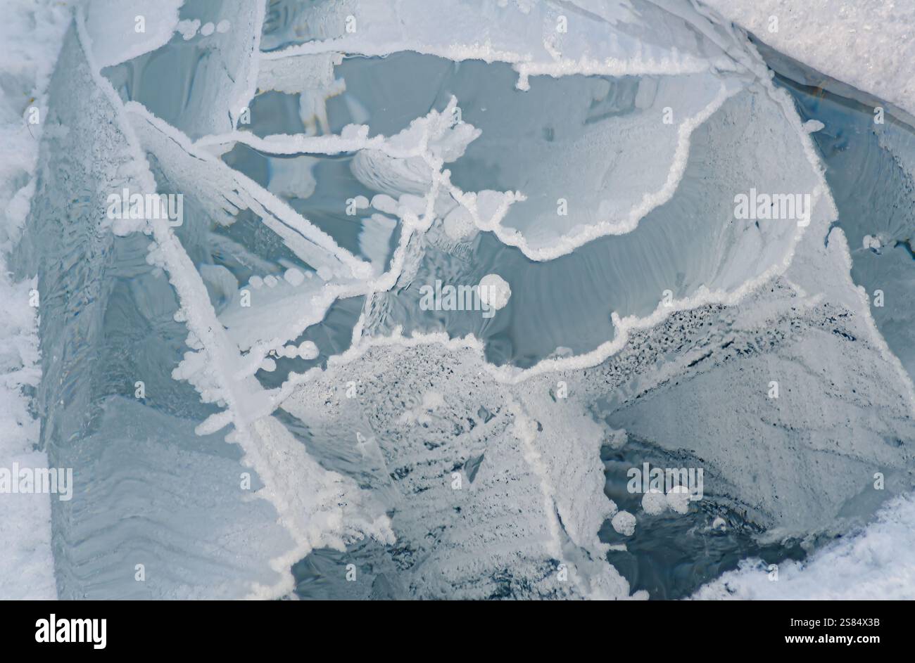 An extreme close up of shore line ice shows patterns, textures and ...