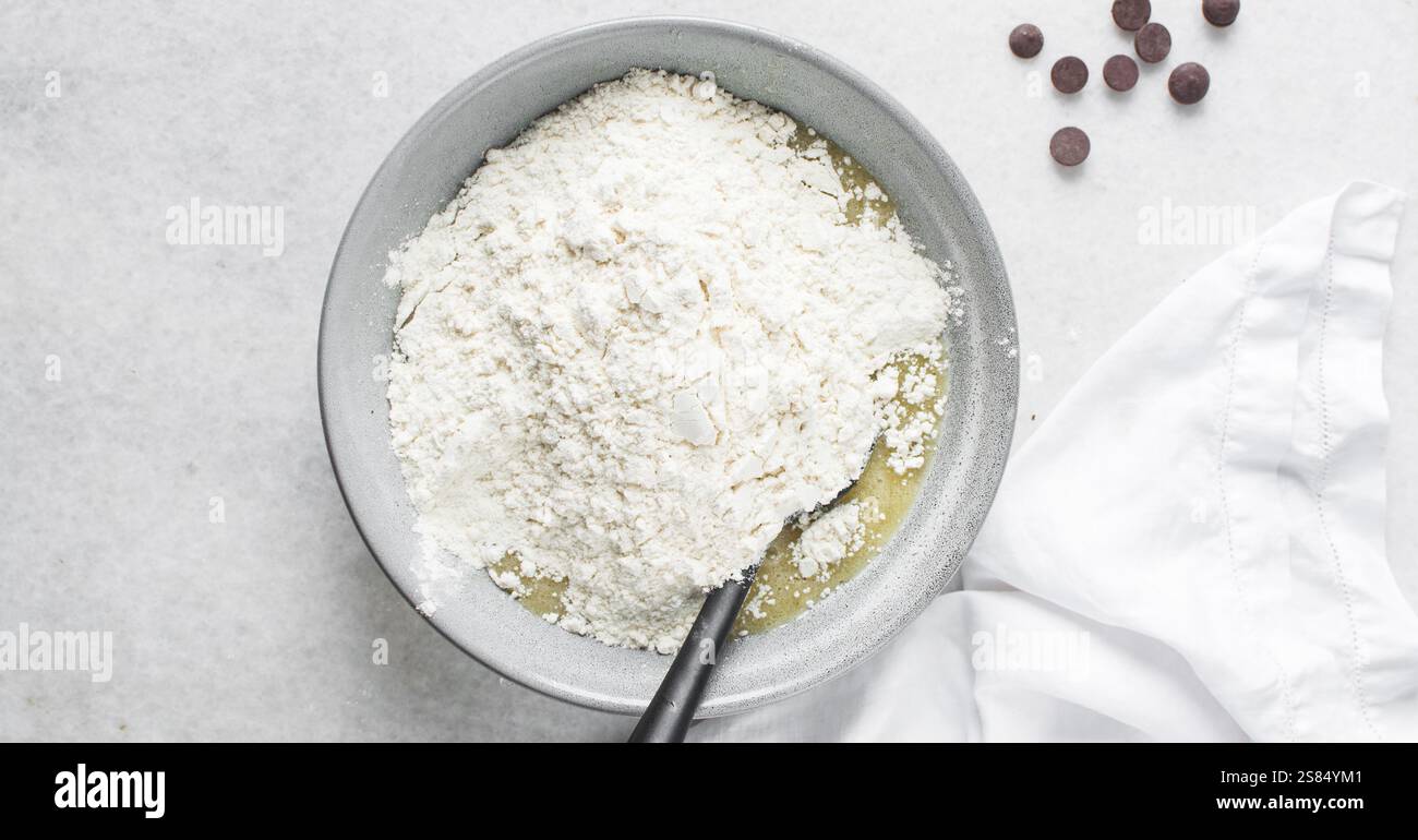 mixing flour into vanilla cookie dough in a white mixing bowl, plain ...
