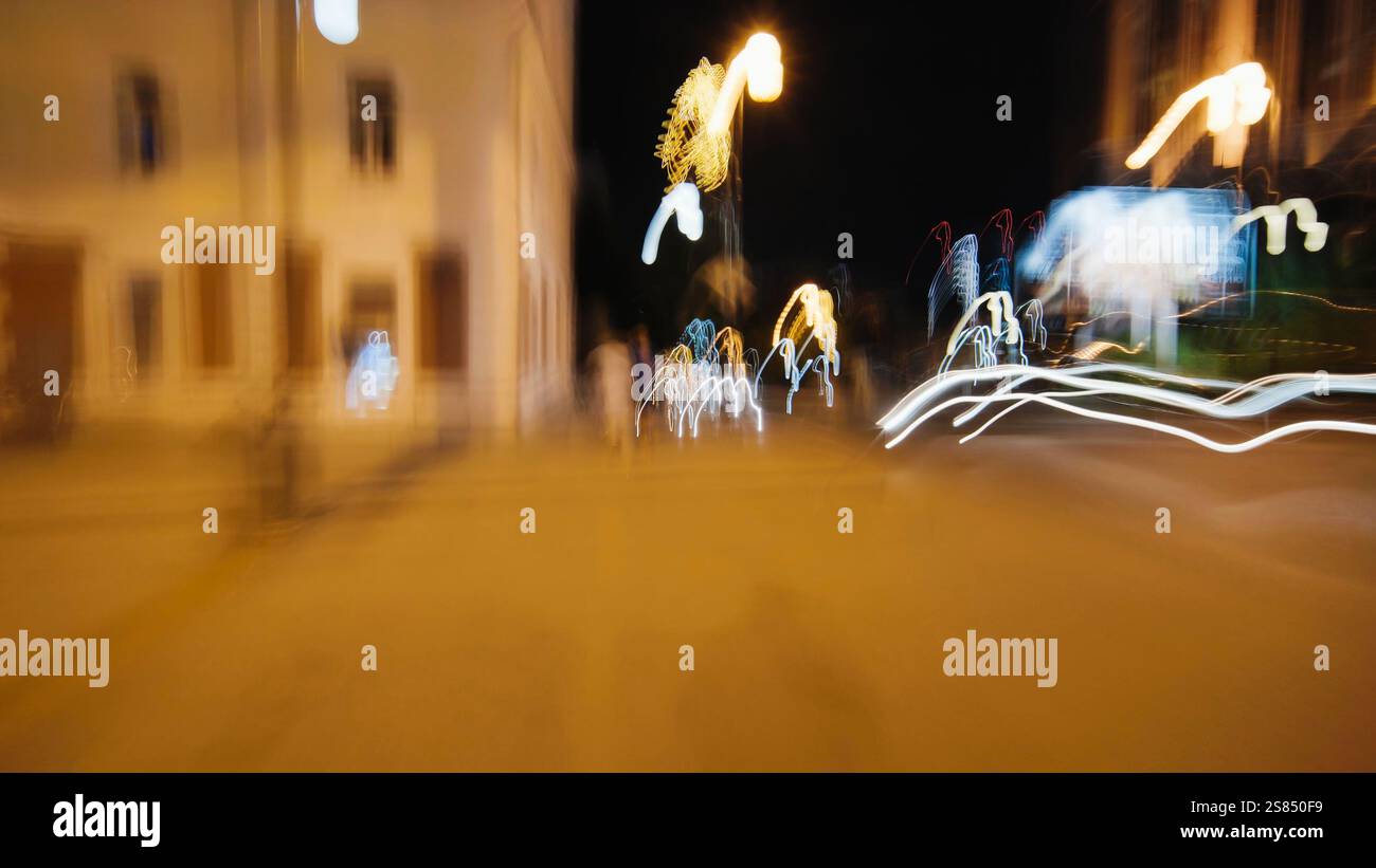 Urban nightscape showing blurred light trails streaming across dark ...