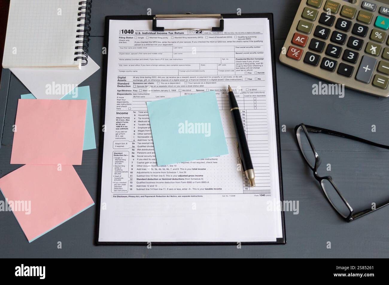 Paper clipboard with 1040 form, glasses, pen, calculator, color ...
