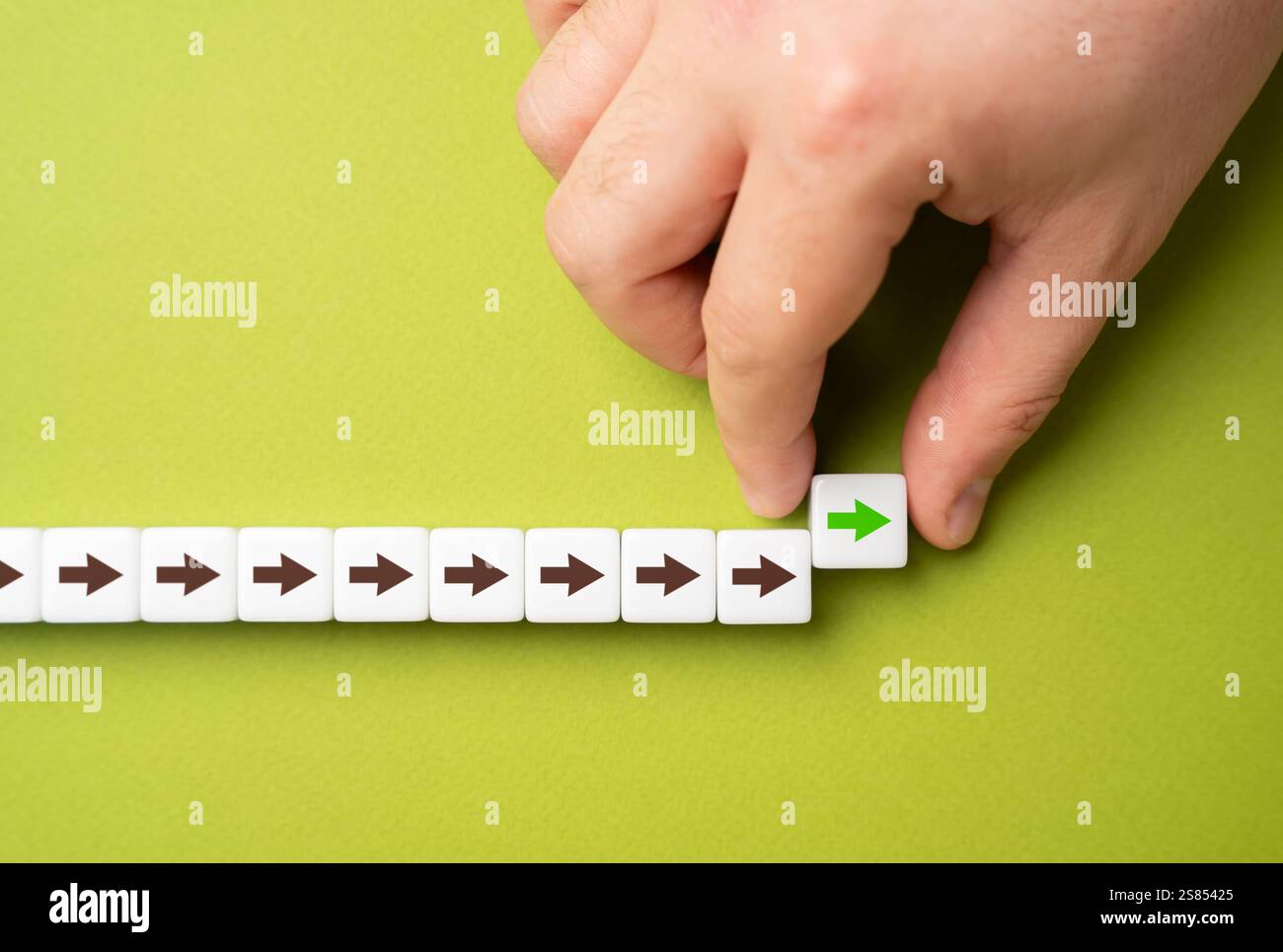 A hand makes a path out of blocks with arrows. The concept of moving ...