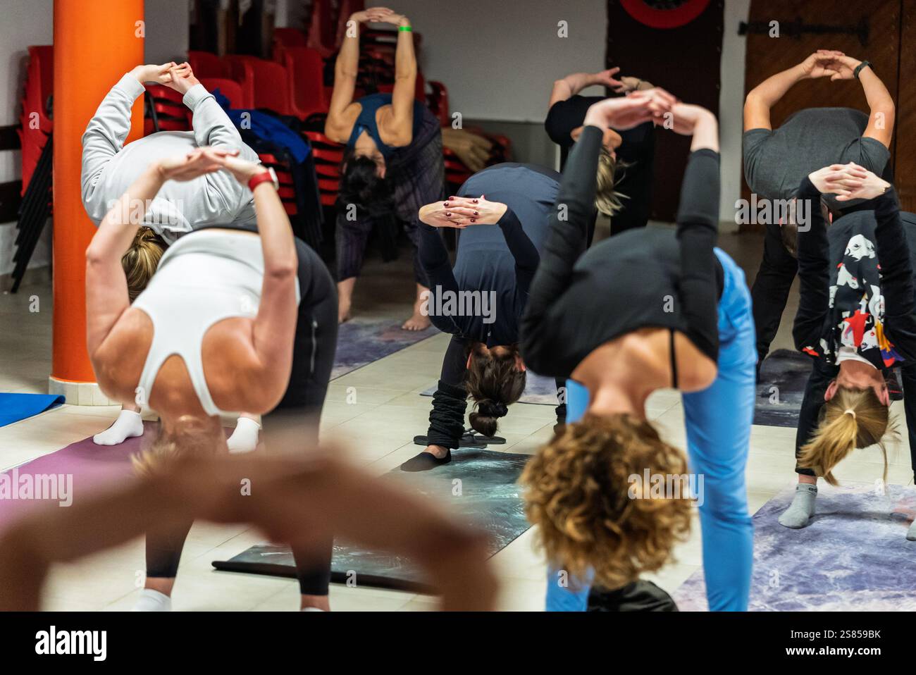 Group of people doing yoga trening. Group Yoga Class Performing a Stretching Pose Stock Photo ...