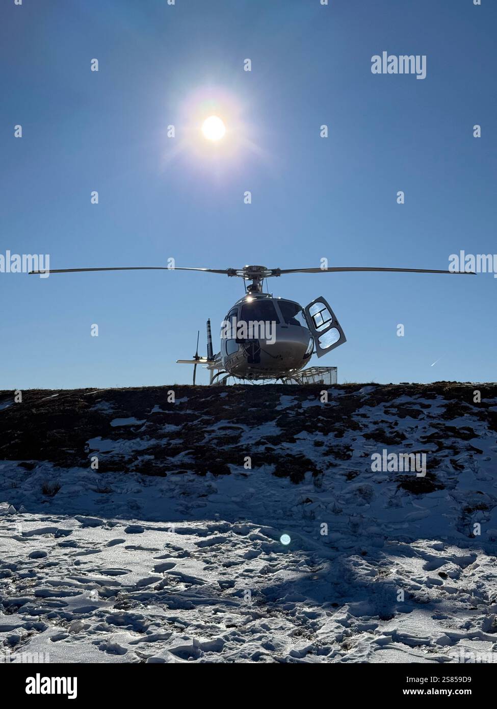 Helicopter on a snowy mountain helipad with a picturesque alpine ...