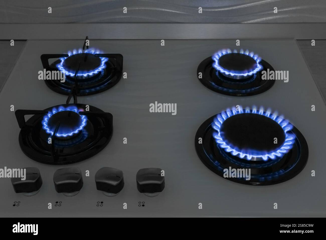 Modern gas cooktop with burning blue flames in kitchen Stock Photo - Alamy