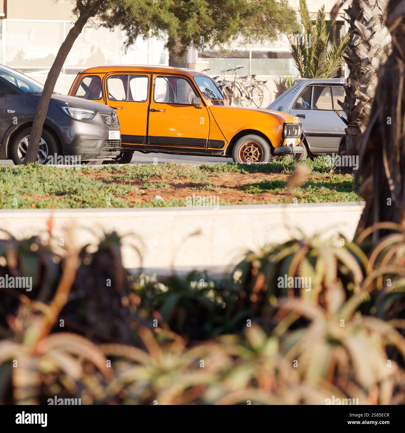 Traditional classic car in orange parked on the street in Essaouira ...