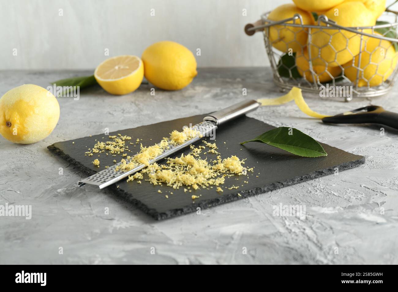 Lemon zest, tools and fresh fruits on grey textured table Stock Photo ...