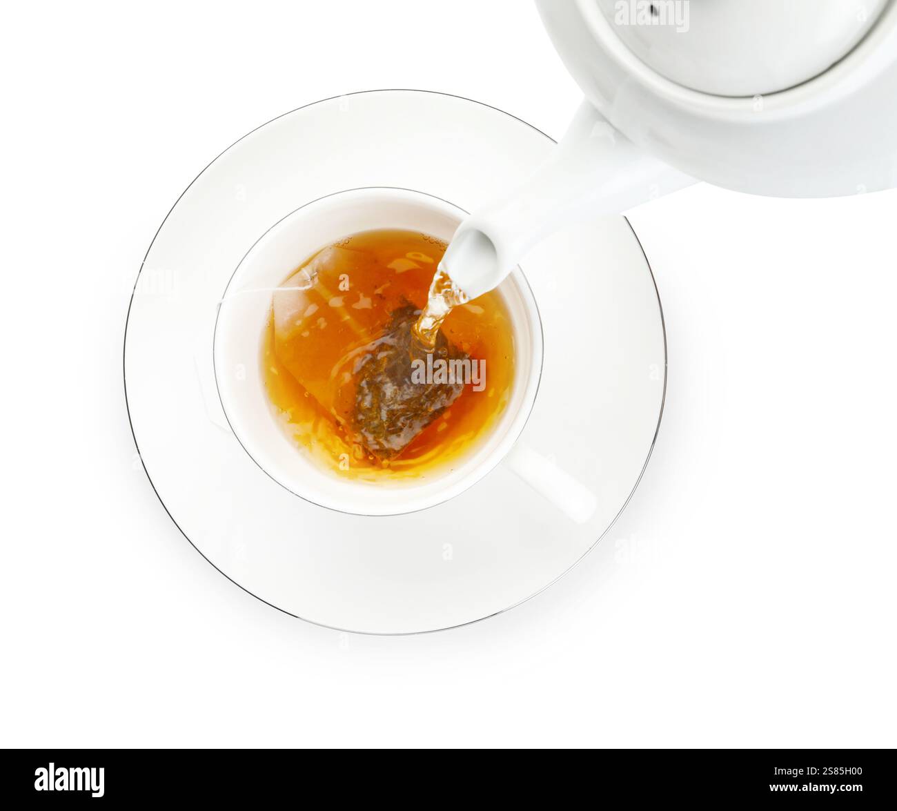 Pouring hot water into cup with tea bag on white background, top view ...