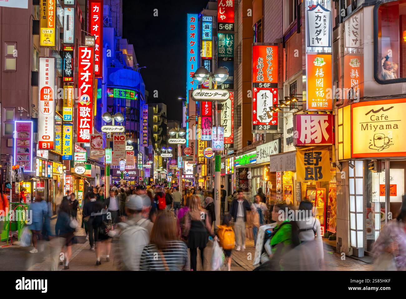 View of busy street and neon lights at night in Shibuya District ...