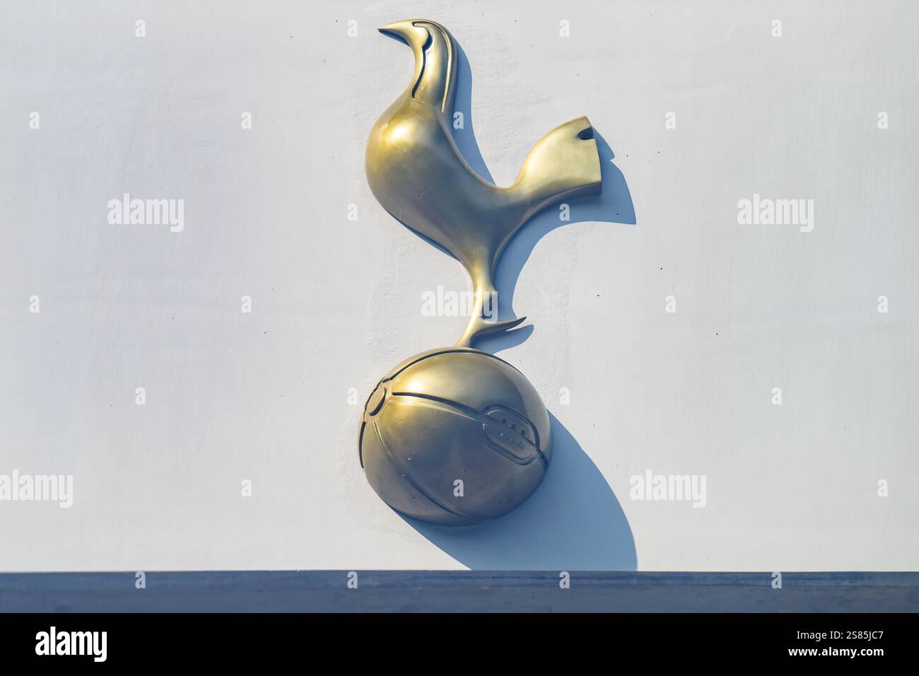 A golden Tottenham Hotspur logo of a golden cockerel standing on a ...