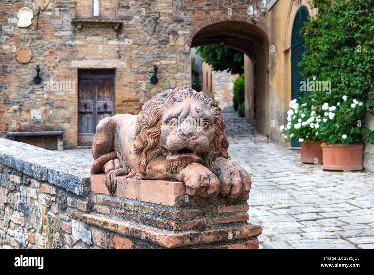 A stone lion guarding the traditional village of Lucignano d'Asso ...
