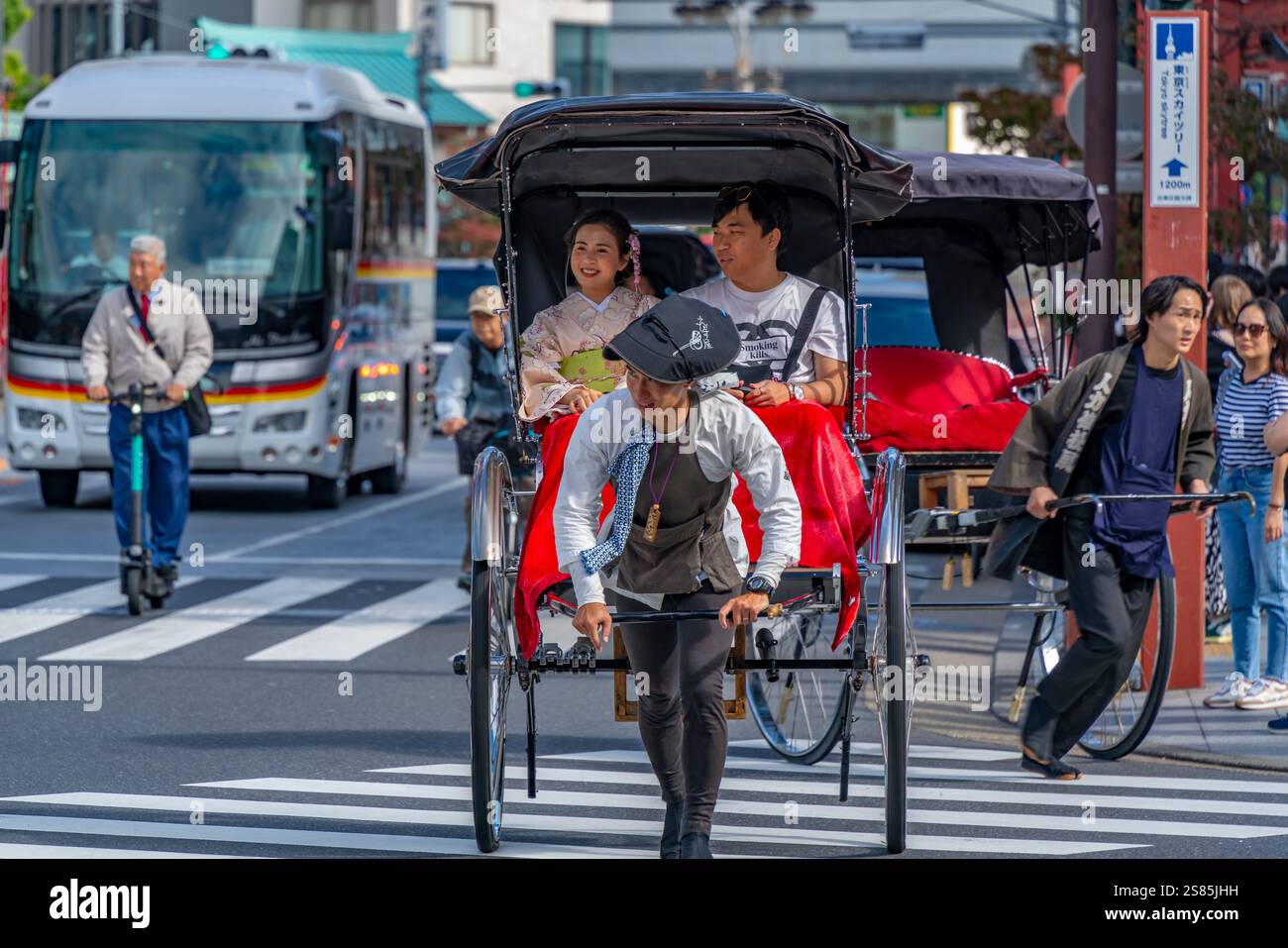 View of Japanese rickshaw (jinrikisha) in busy street scene, Asakusa ...